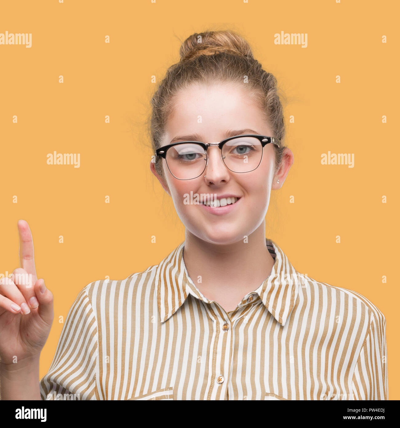 Young blonde business woman showing and pointing up with finger number ...