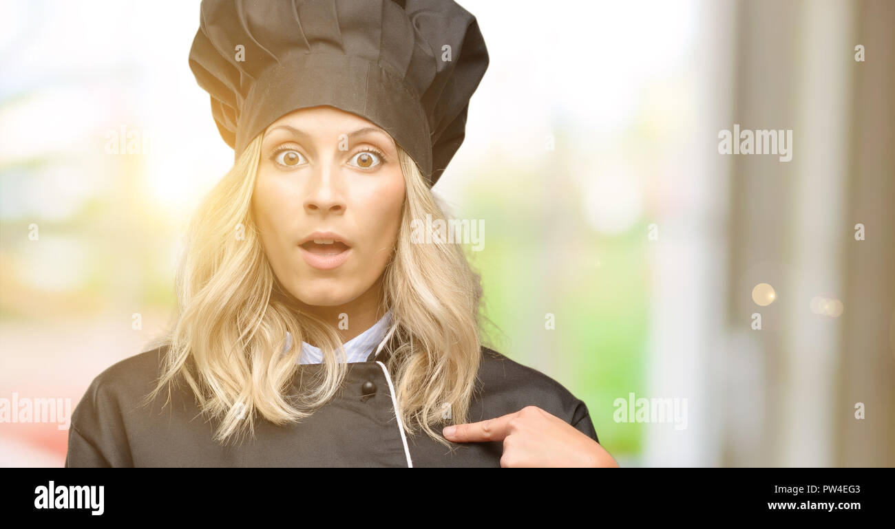 Beautiful cook woman chef happy and surprised cheering expressing wow ...