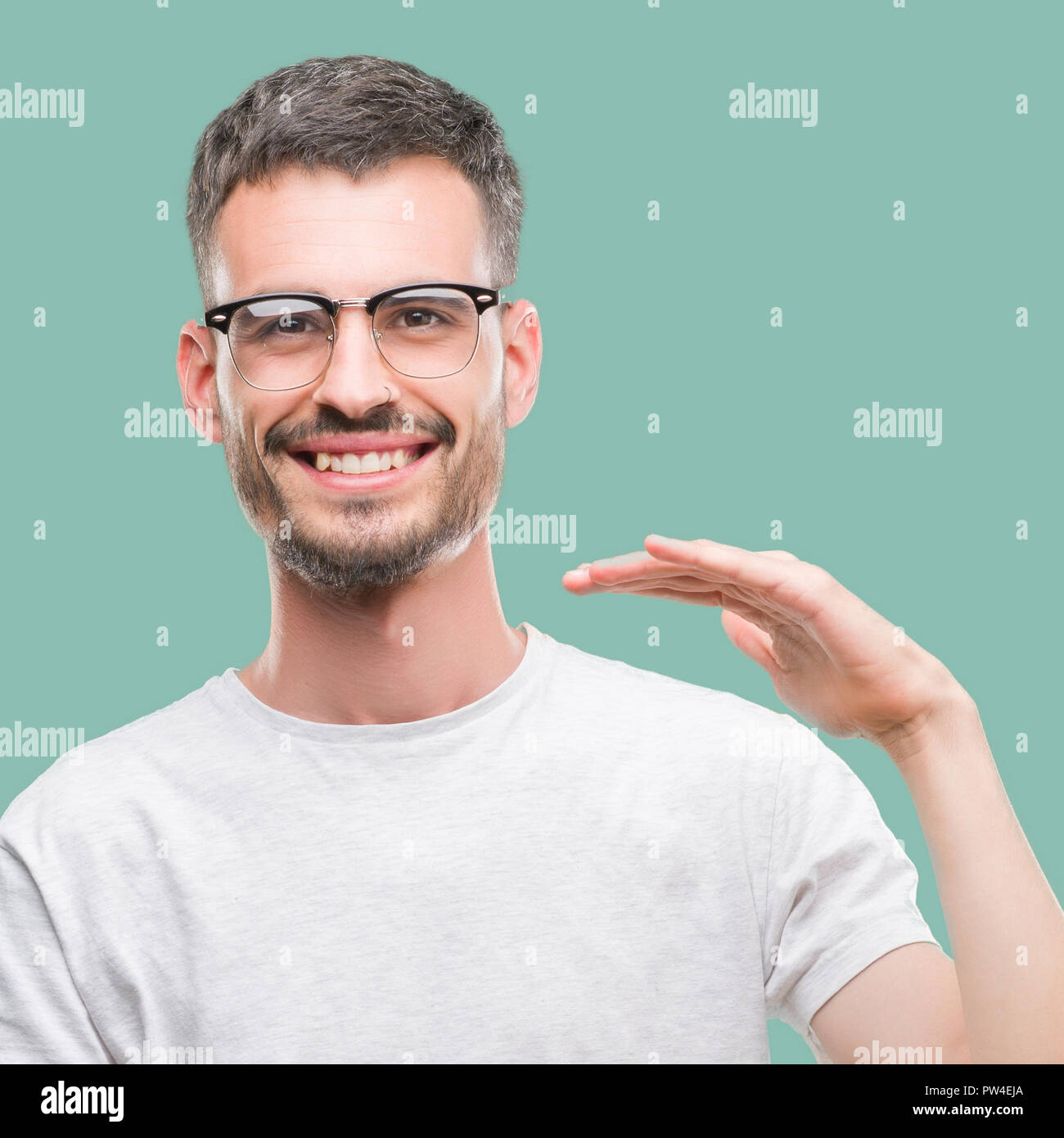 Young tattooed adult man gesturing with hands showing big and large ...