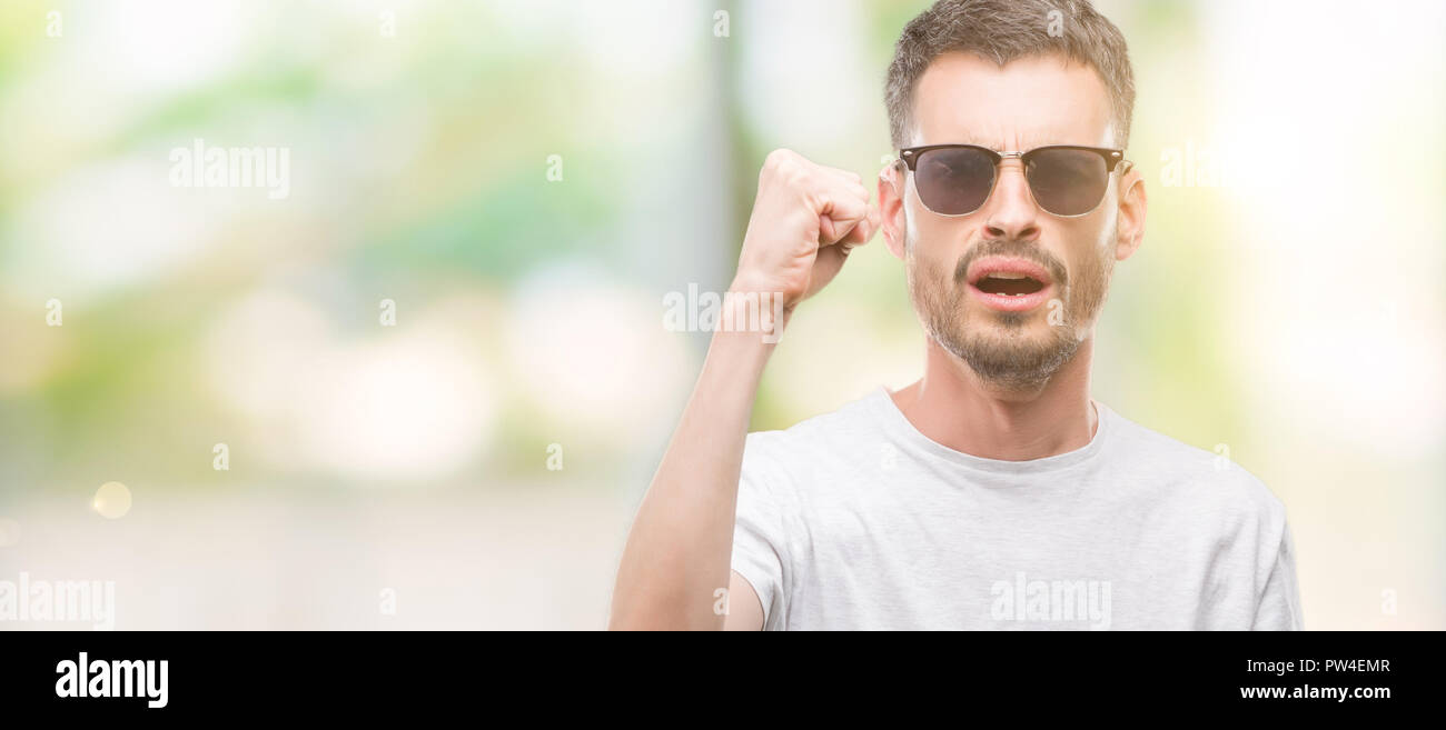 Young tattooed adult man wearing sunglasses annoyed and frustrated ...