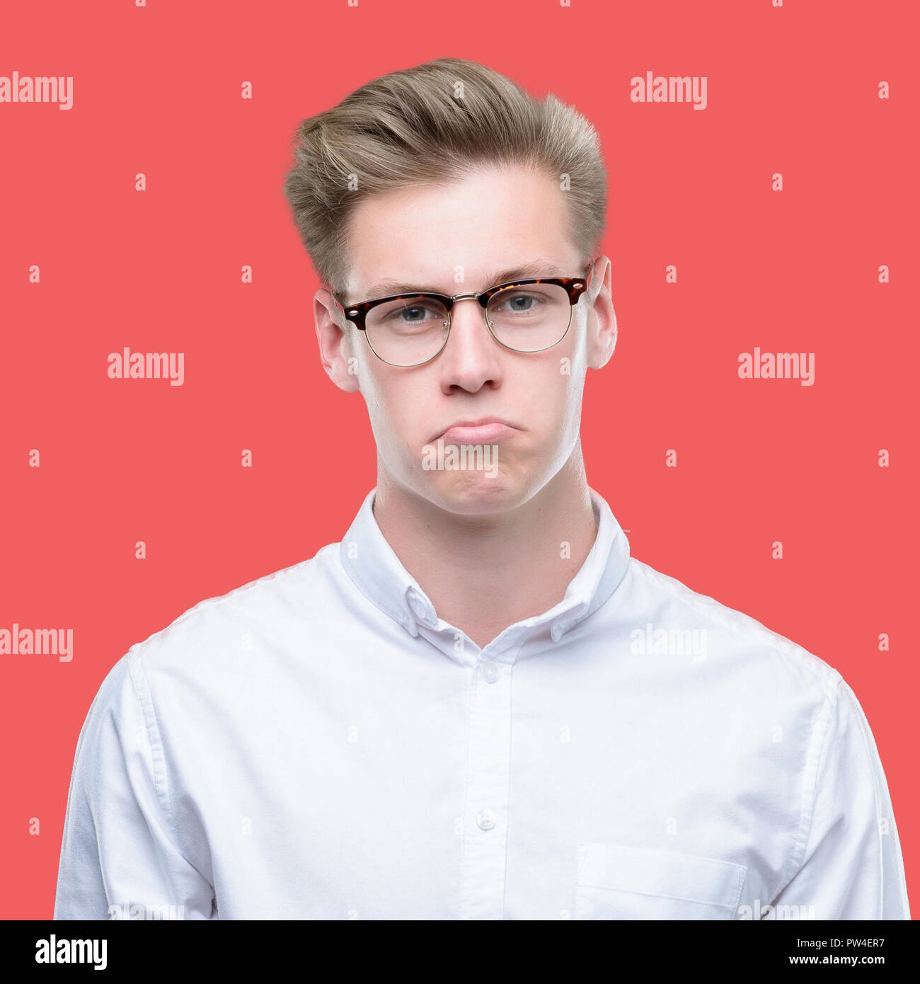 Young handsome blond man depressed and worry for distress, crying angry ...