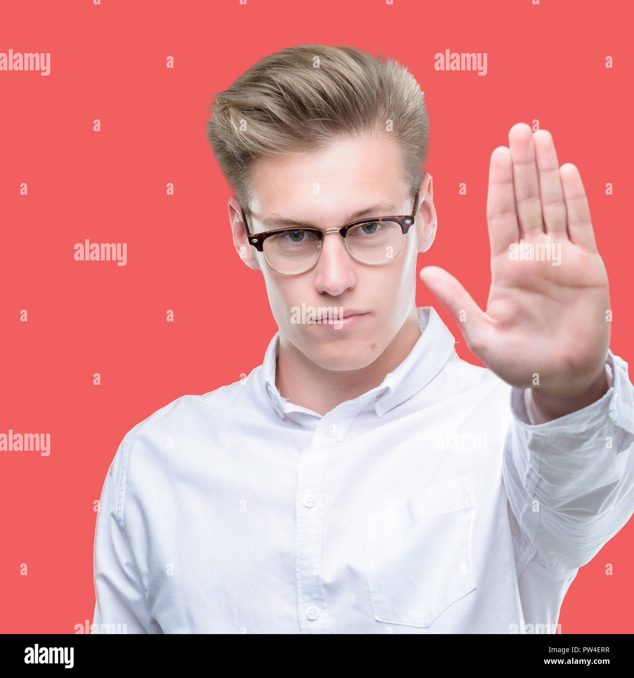 Young handsome blond man doing stop sing with palm of the hand. Warning ...