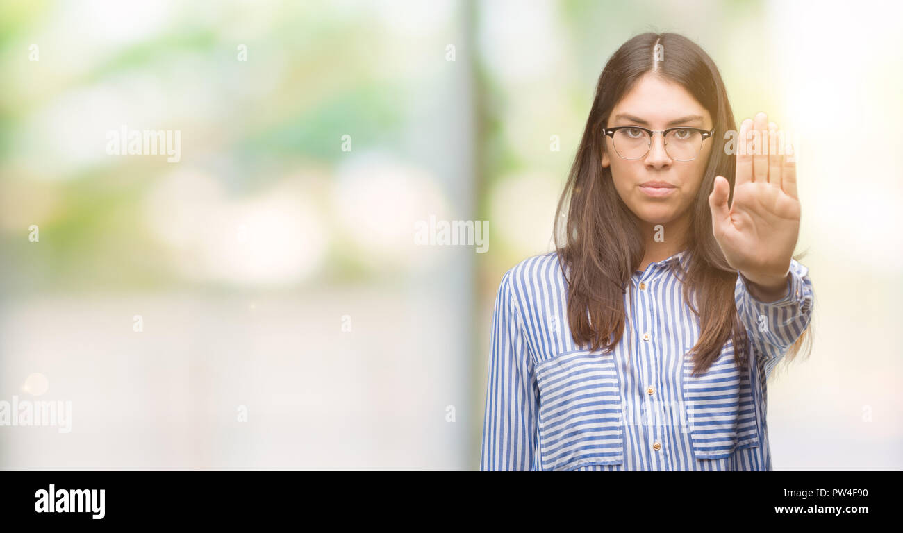 Young beautiful hispanic business woman doing stop sing with palm of ...