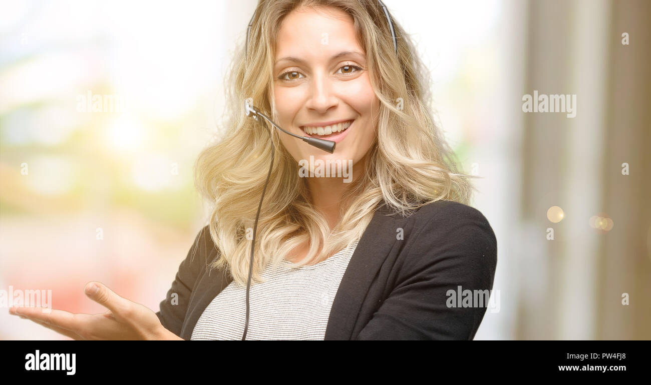 Young woman operator from call center holding something in empty hand ...