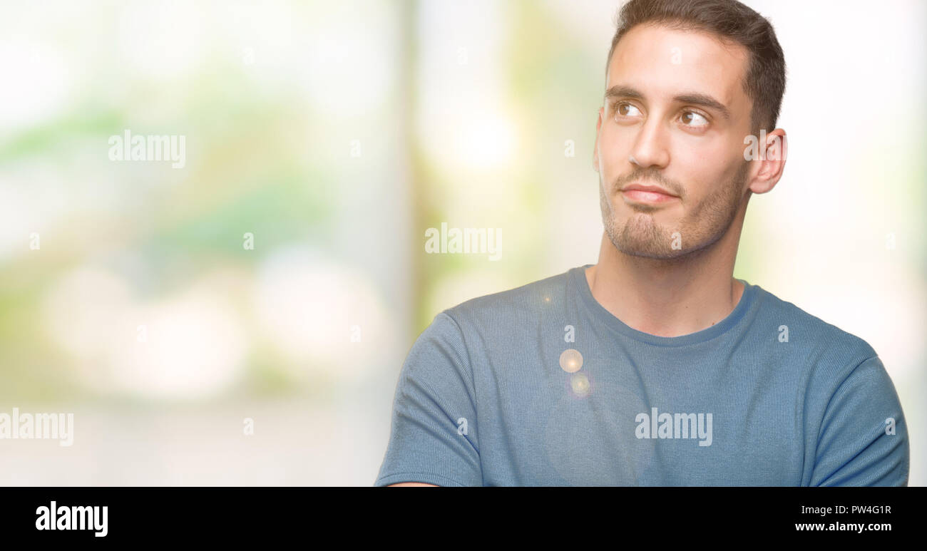 Handsome young casual man smiling looking side and staring away ...