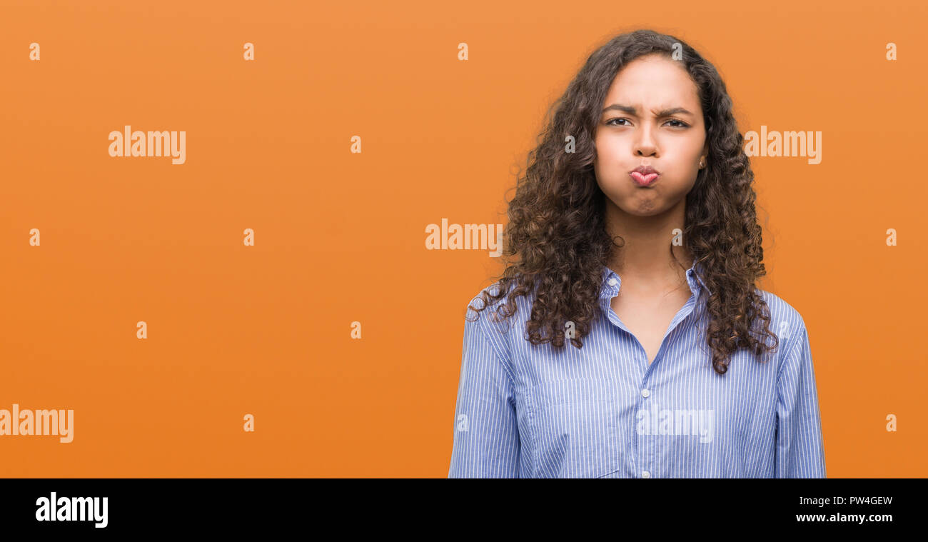 Young hispanic business woman puffing cheeks with funny face. Mouth ...