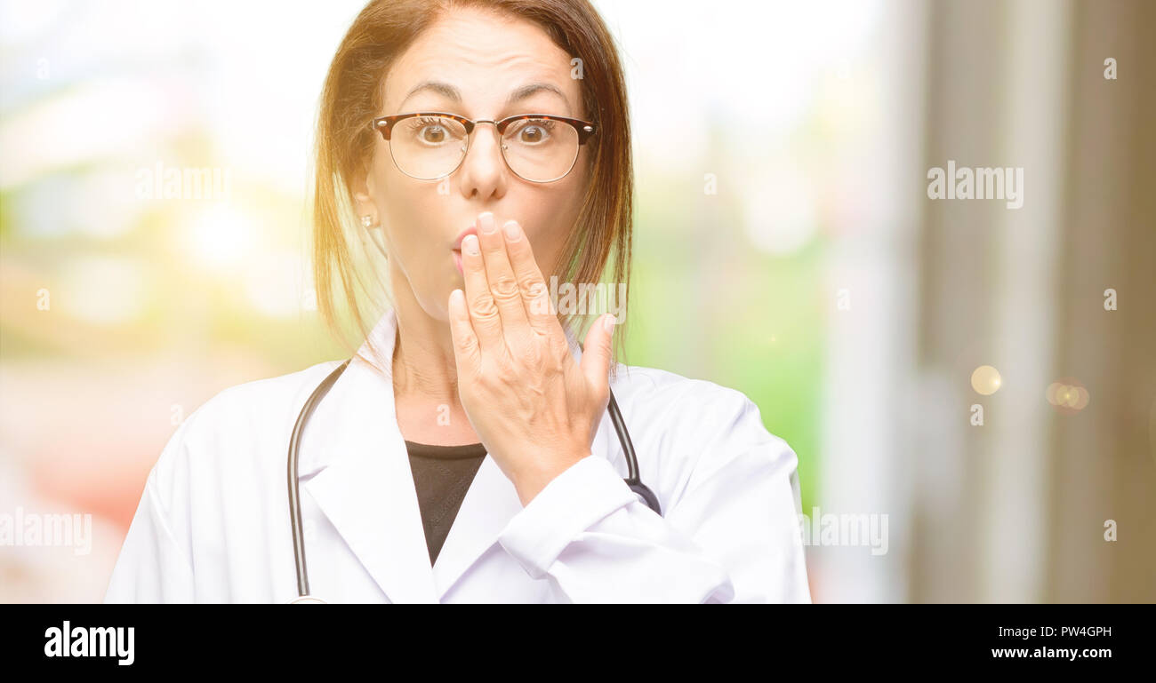 Doctor woman, medical professional covers mouth in shock, looks shy ...