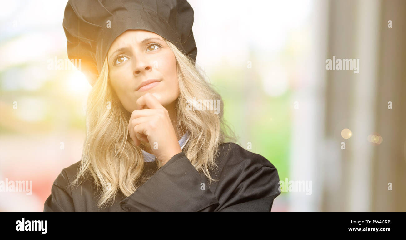 Beautiful cook woman chef thinking and looking up expressing doubt and ...