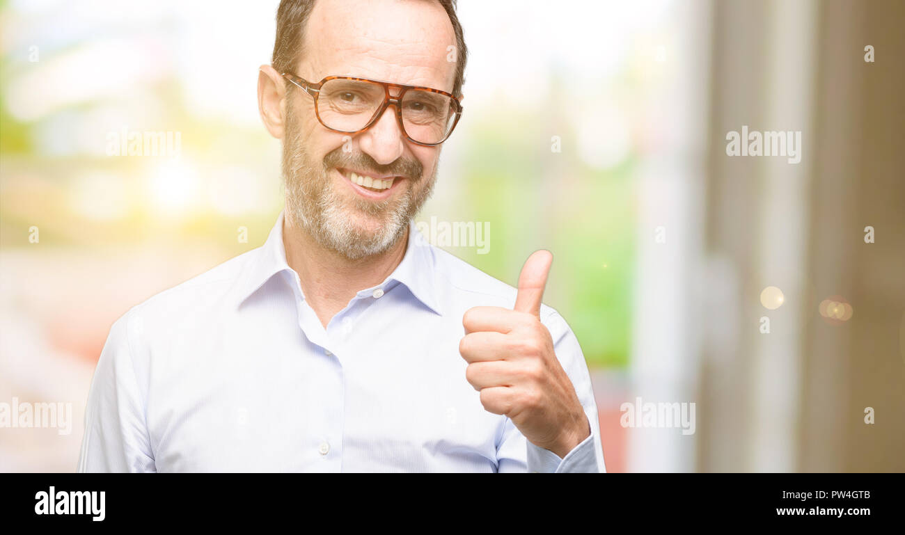 Middle age man with glasses smiling broadly showing thumbs up gesture ...