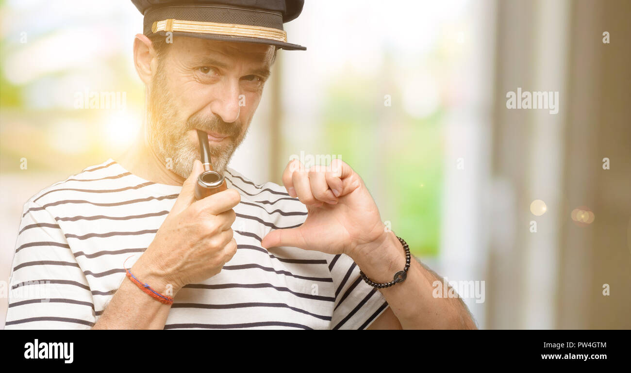 Sailor captain man smoking a tobacco pipe proud, excited and arrogant ...