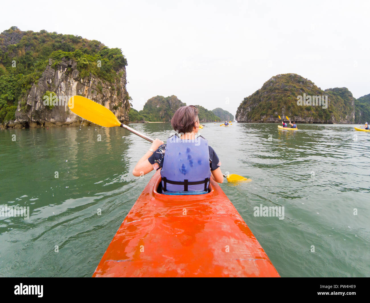 Kayaking amonst the islands of Ha Long Bay on a stormy summers day in ...