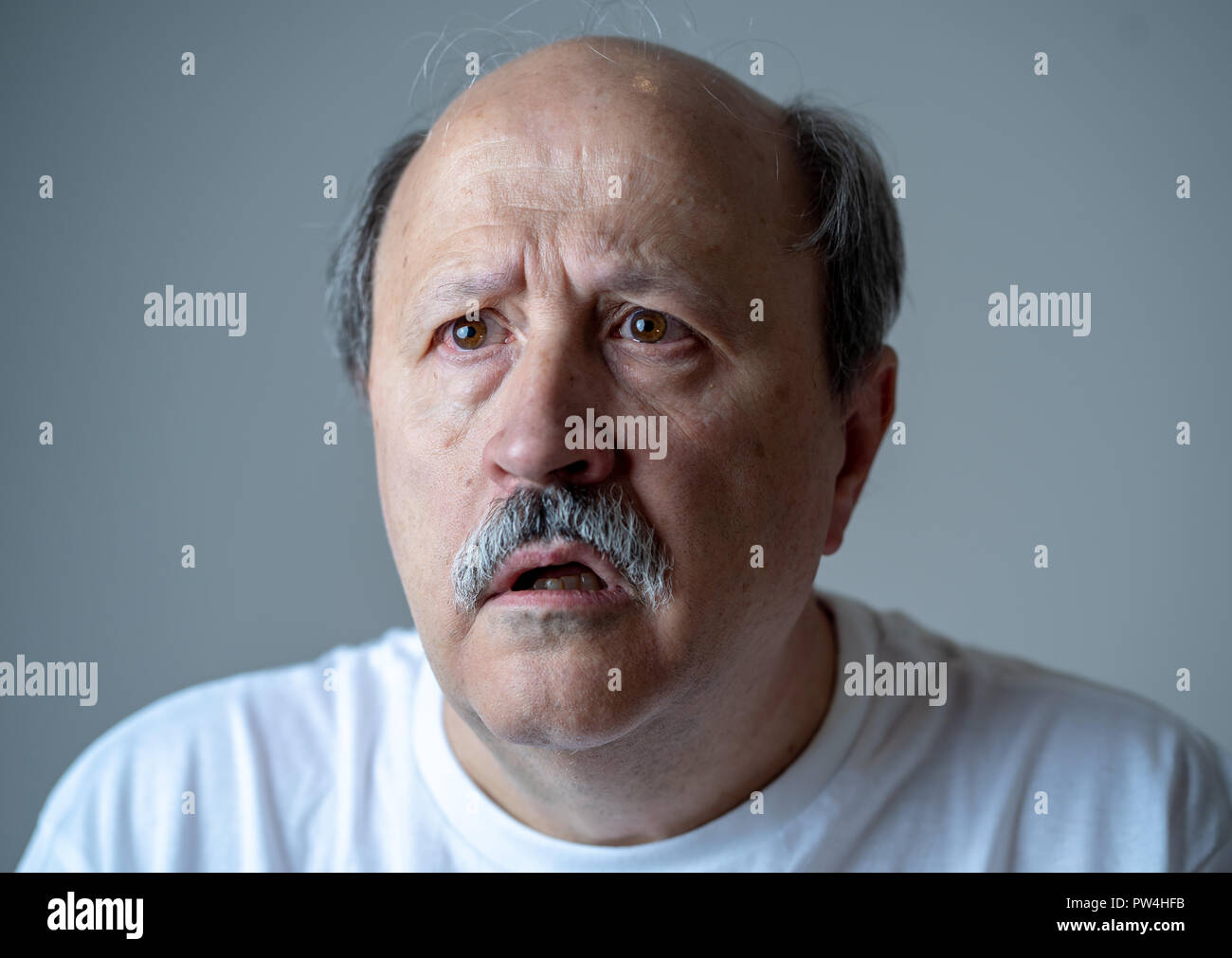 Close up portrait of senior man looking confused and lost suffering ...