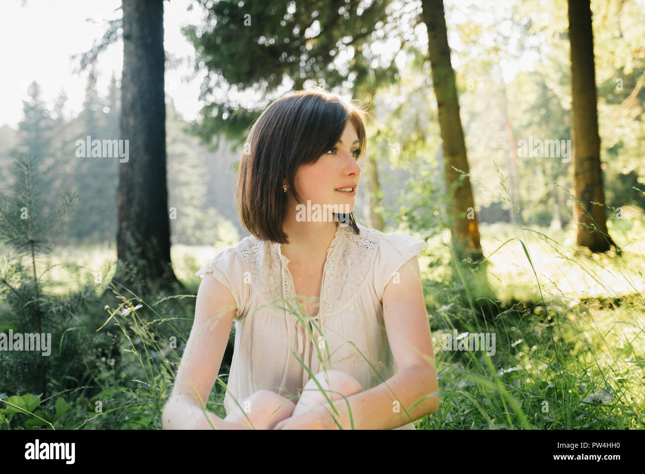 Young woman sitting in forest hi-res stock photography and images - Alamy