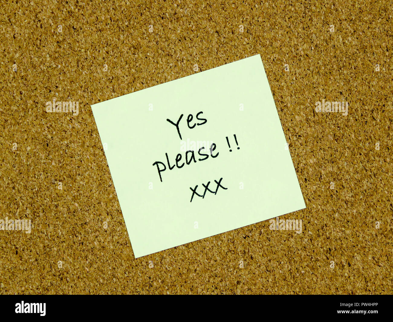 A yellow sticky note with yes please written on it on a cork board ...