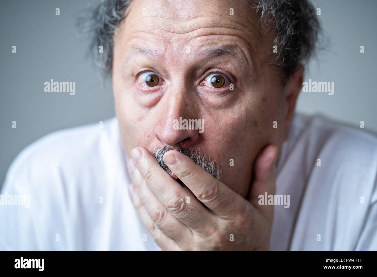 Close up portrait of a scared frightened old man in expression of fear ...