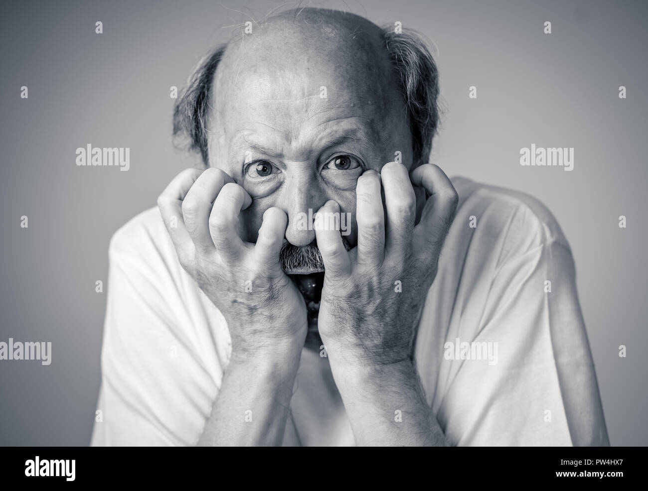 Close up portrait of a scared frightened old man in expression of fear ...