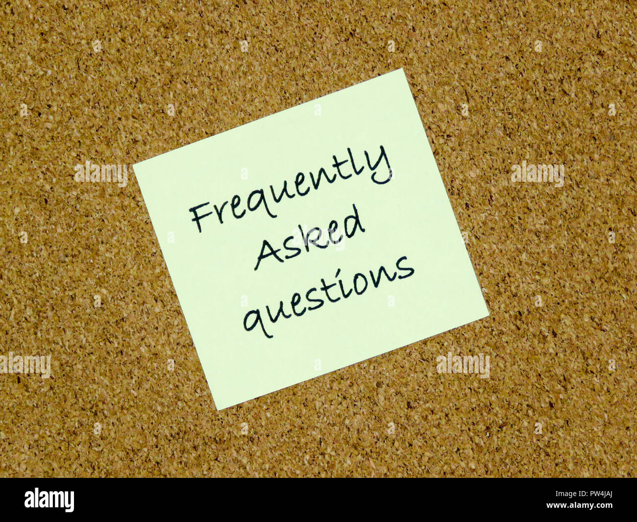 A yellow sticky note with frequently asked questions written on it on a ...