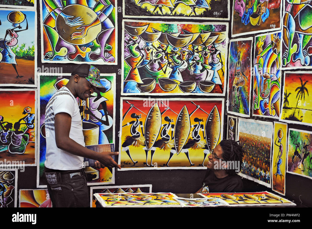 Young africans talking and laughing in their African tribal print shop ...