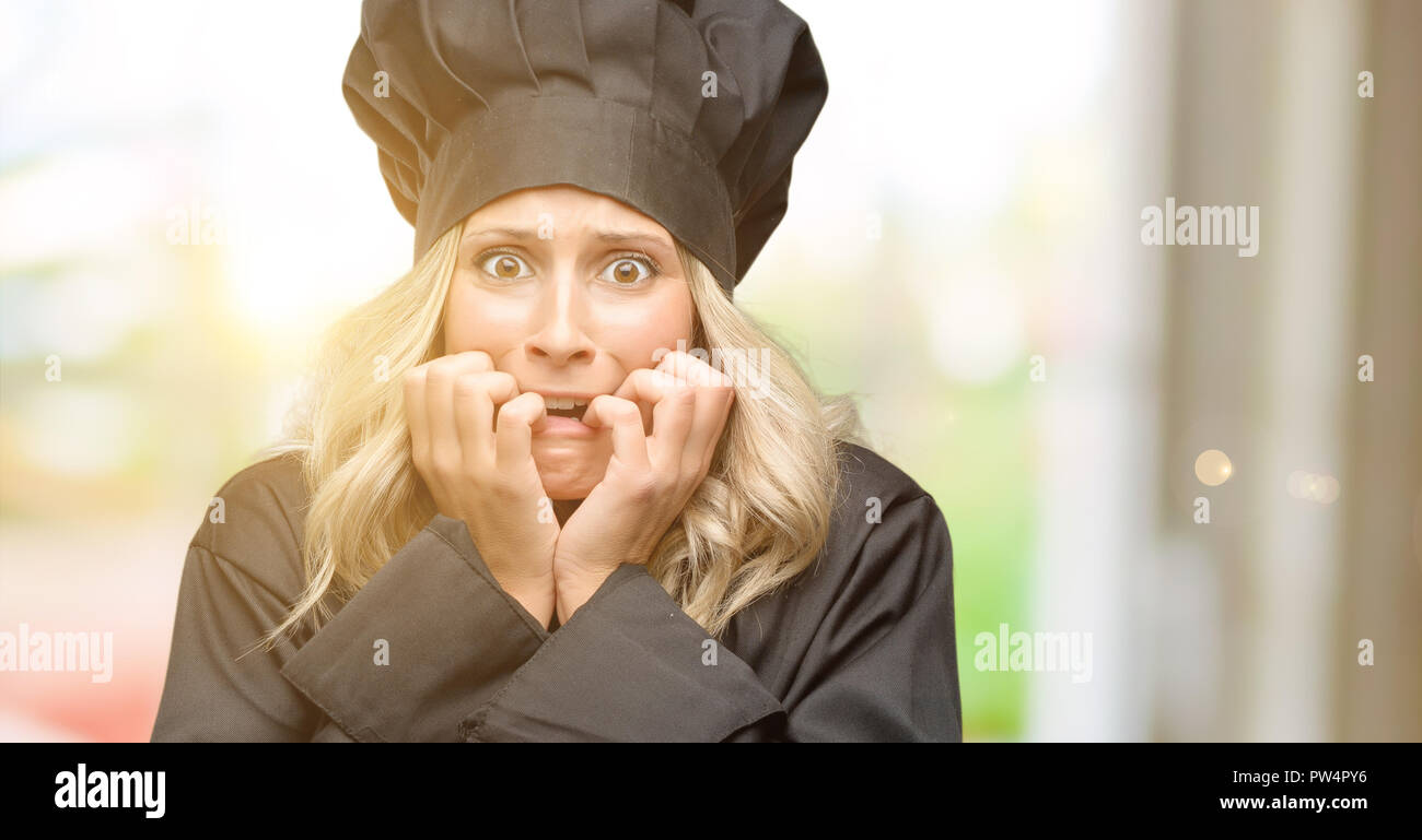 Beautiful cook woman chef terrified and nervous expressing anxiety and ...