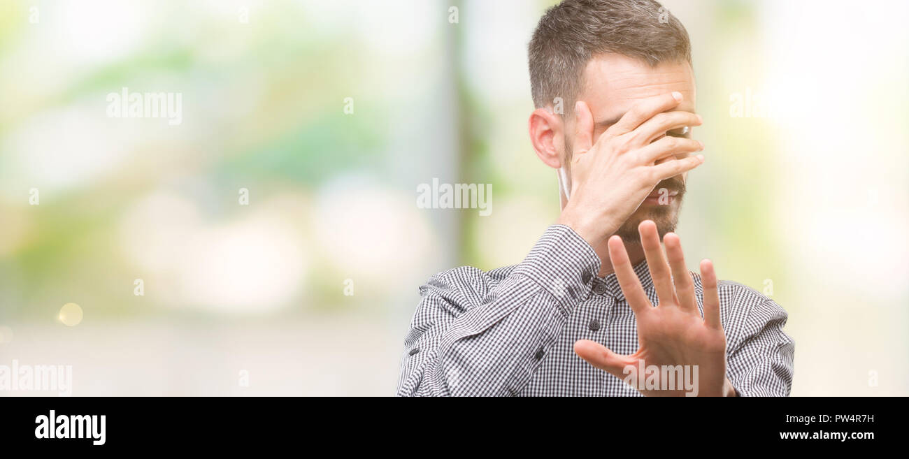 Young hipster man covering eyes with hands and doing stop gesture with ...