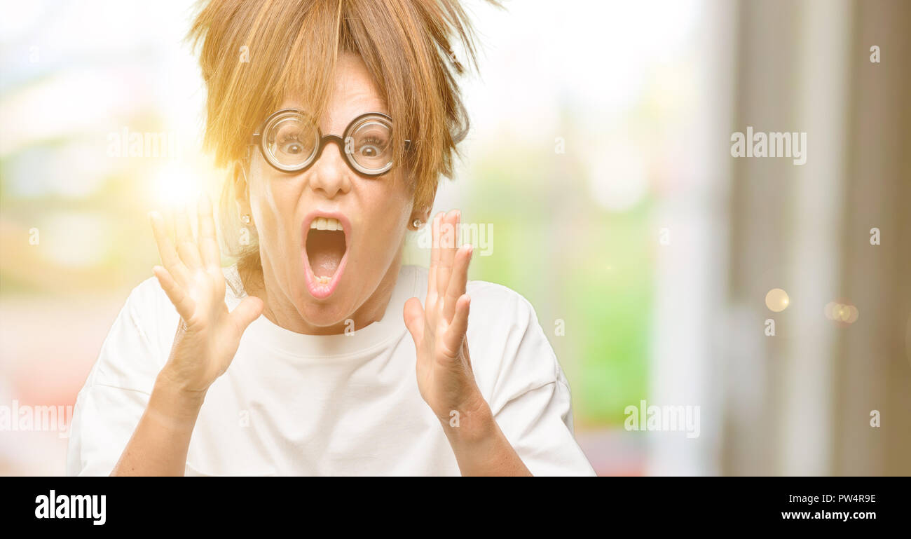 Crazy middle age woman wearing silly glasses stressful keeping hands on ...