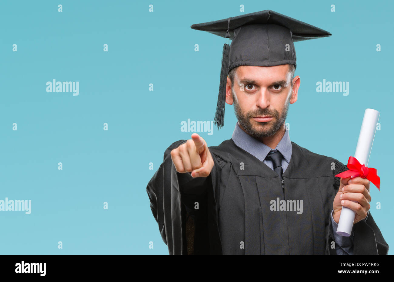 Young handsome graduated man holding degree over isolated background ...