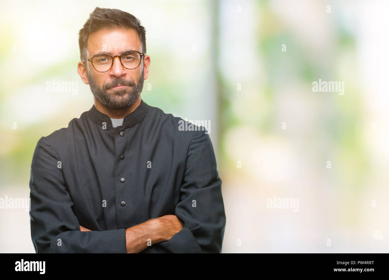 Adult hispanic catholic priest man over isolated background skeptic and ...