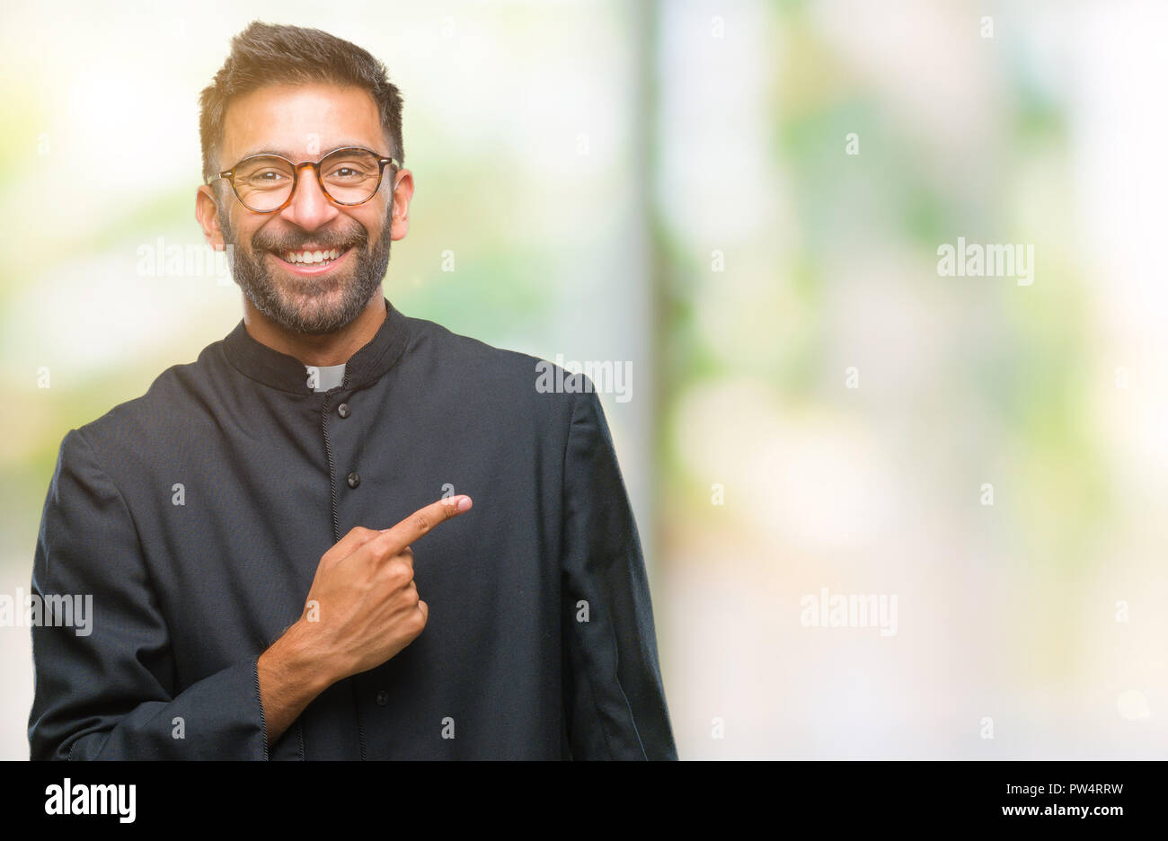 Adult hispanic catholic priest man over isolated background cheerful ...