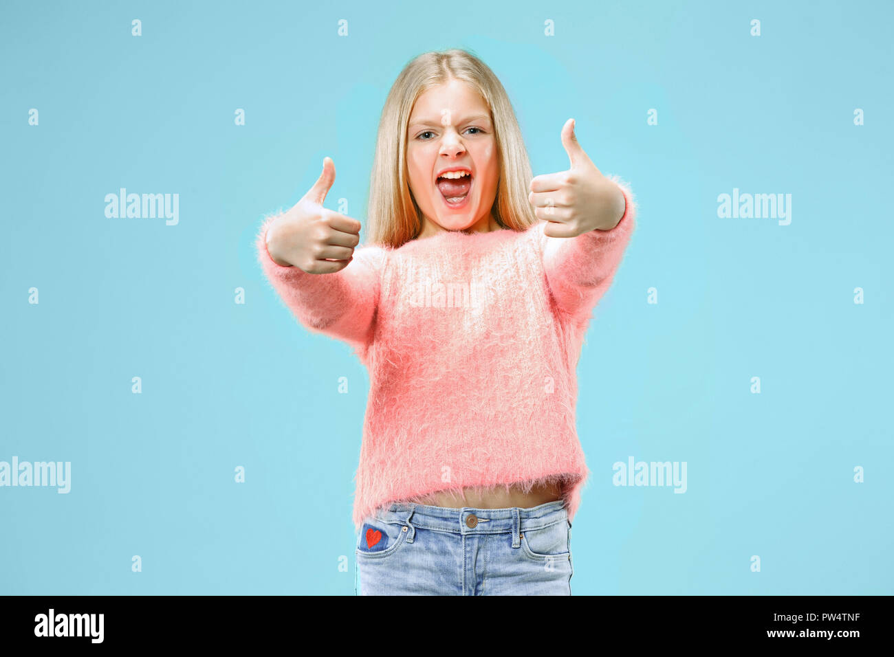 Happy teen girl standing, smiling isolated on trendy blue studio ...