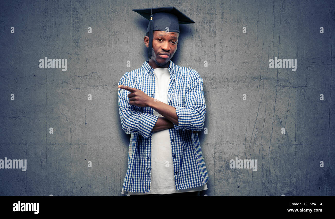 Young african graduate student black man pointing away side with finger ...
