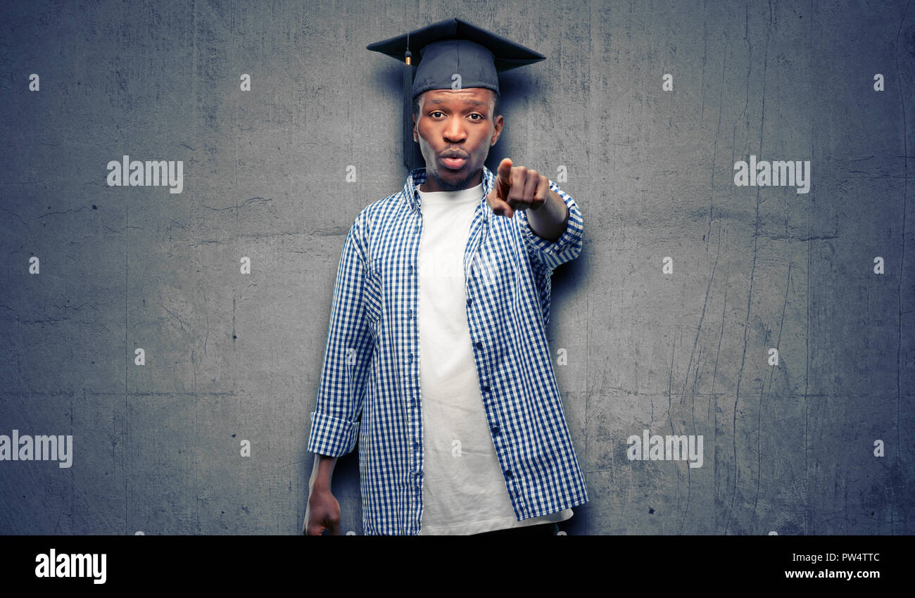 Young african graduate student black man pointing to the front with ...