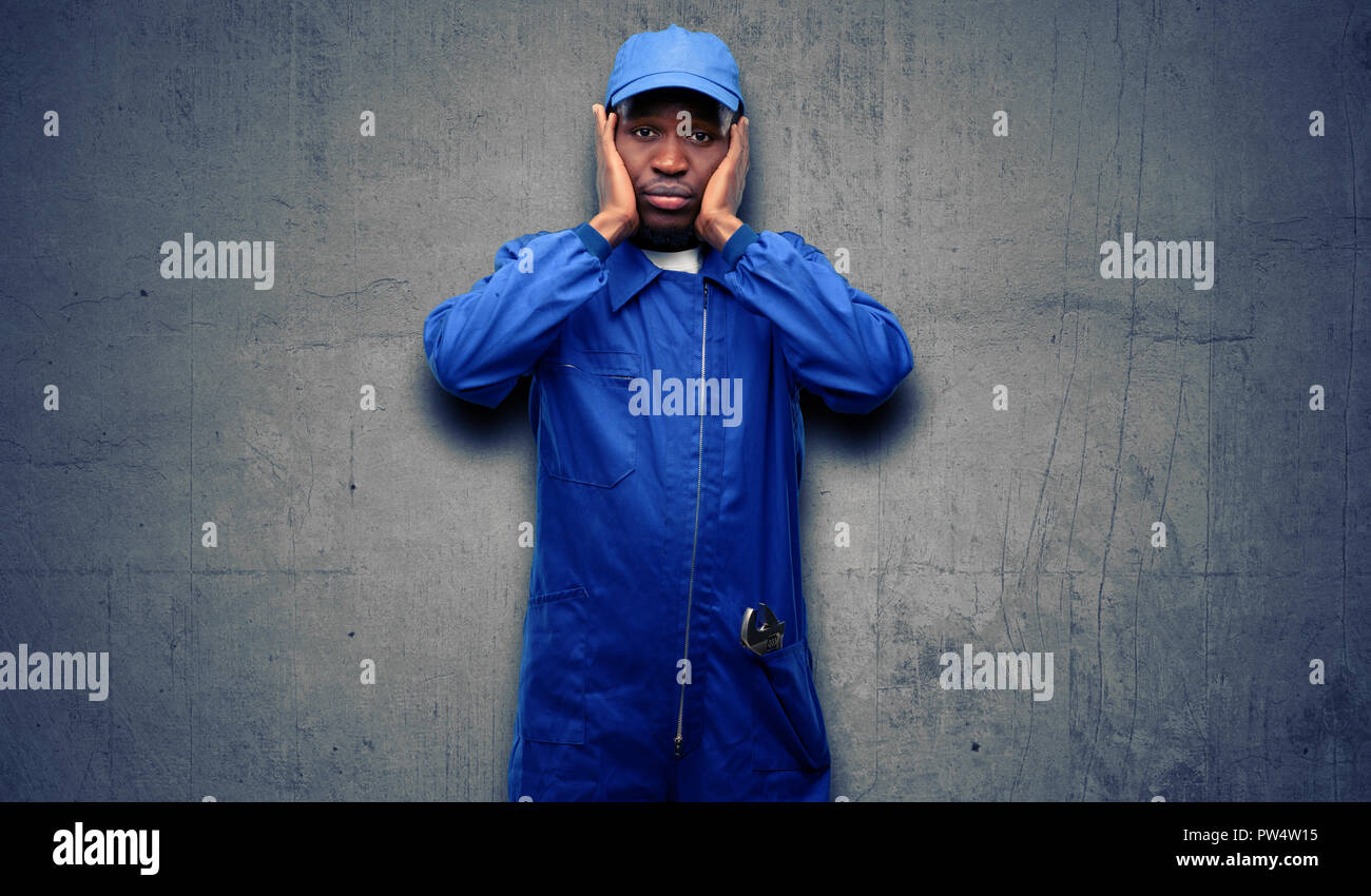 African black plumber man covering ears ignoring annoying loud noise ...