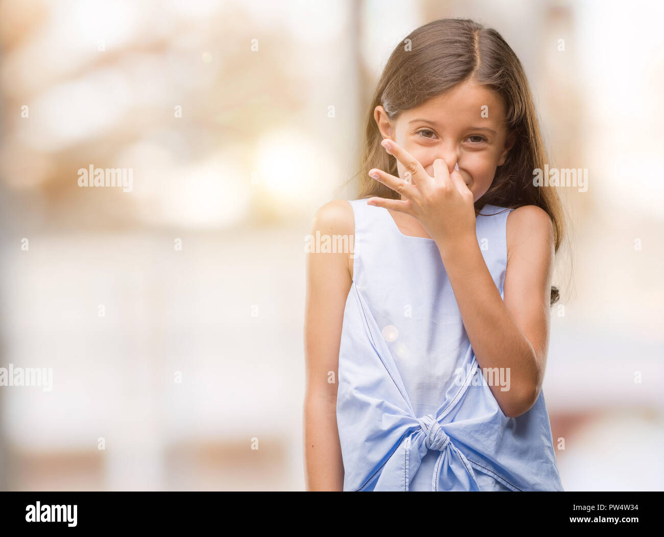 Brunette hispanic girl smelling something stinky and disgusting ...