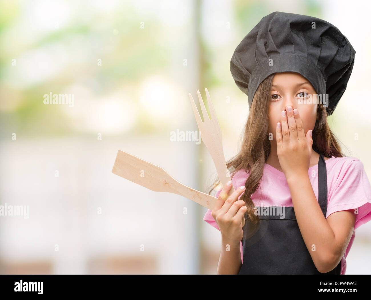 Brunette hispanic girl wearing cook uniform cover mouth with hand ...