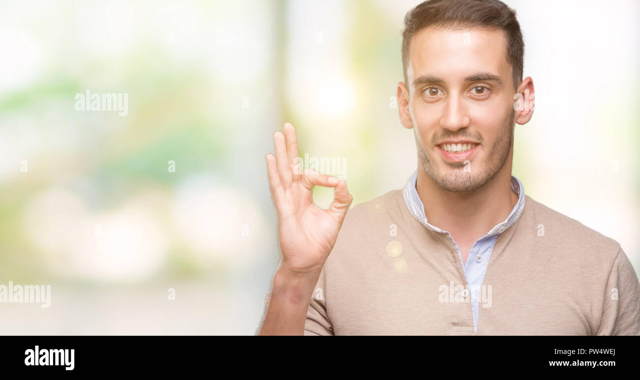 Handsome young man doing ok sign with fingers, excellent symbol Stock ...