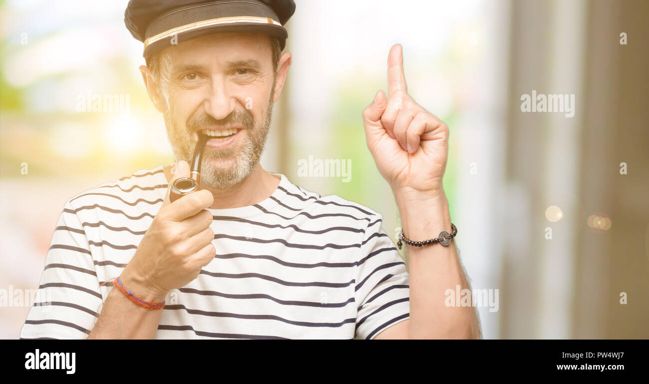Sailor captain man smoking a tobacco pipe raising finger, the number ...