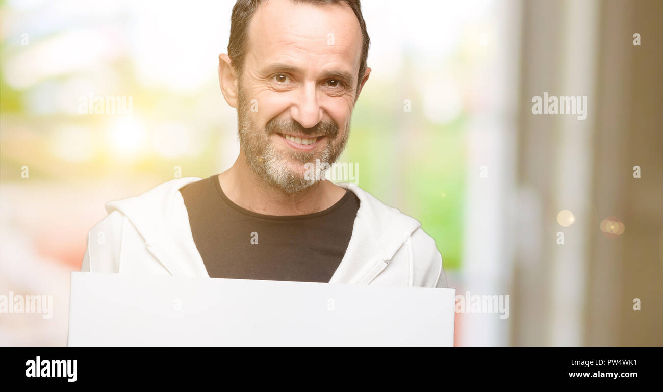 Middle age man wearing sportswear holding blank advertising banner ...