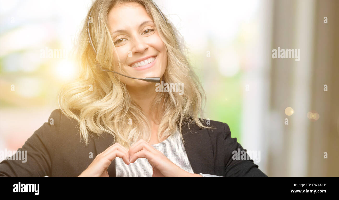 Young woman operator from call center happy showing love with hands in ...