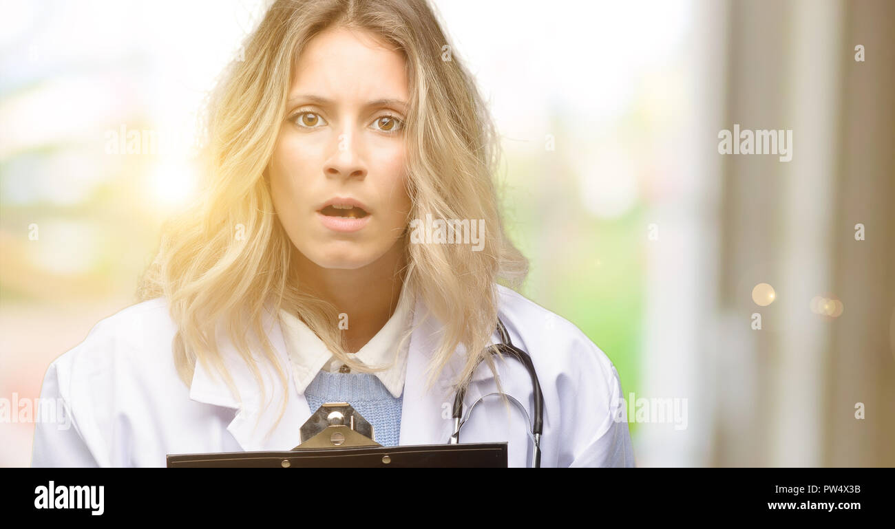 Young doctor woman, medical professional scared in shock, expressing ...