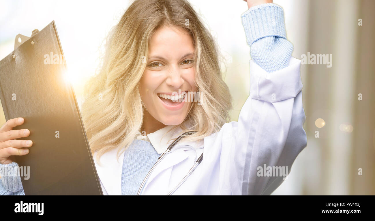 Young doctor woman, medical professional happy and excited celebrating ...