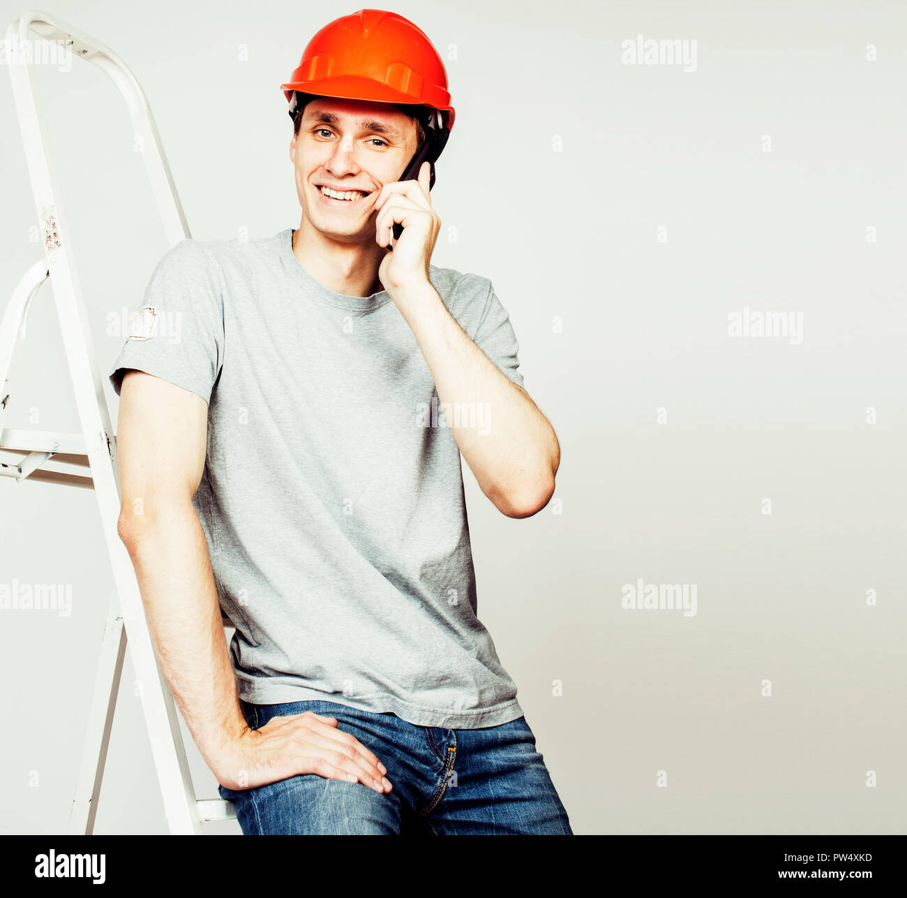 young real hard worker man isolated on white background on ladde Stock ...