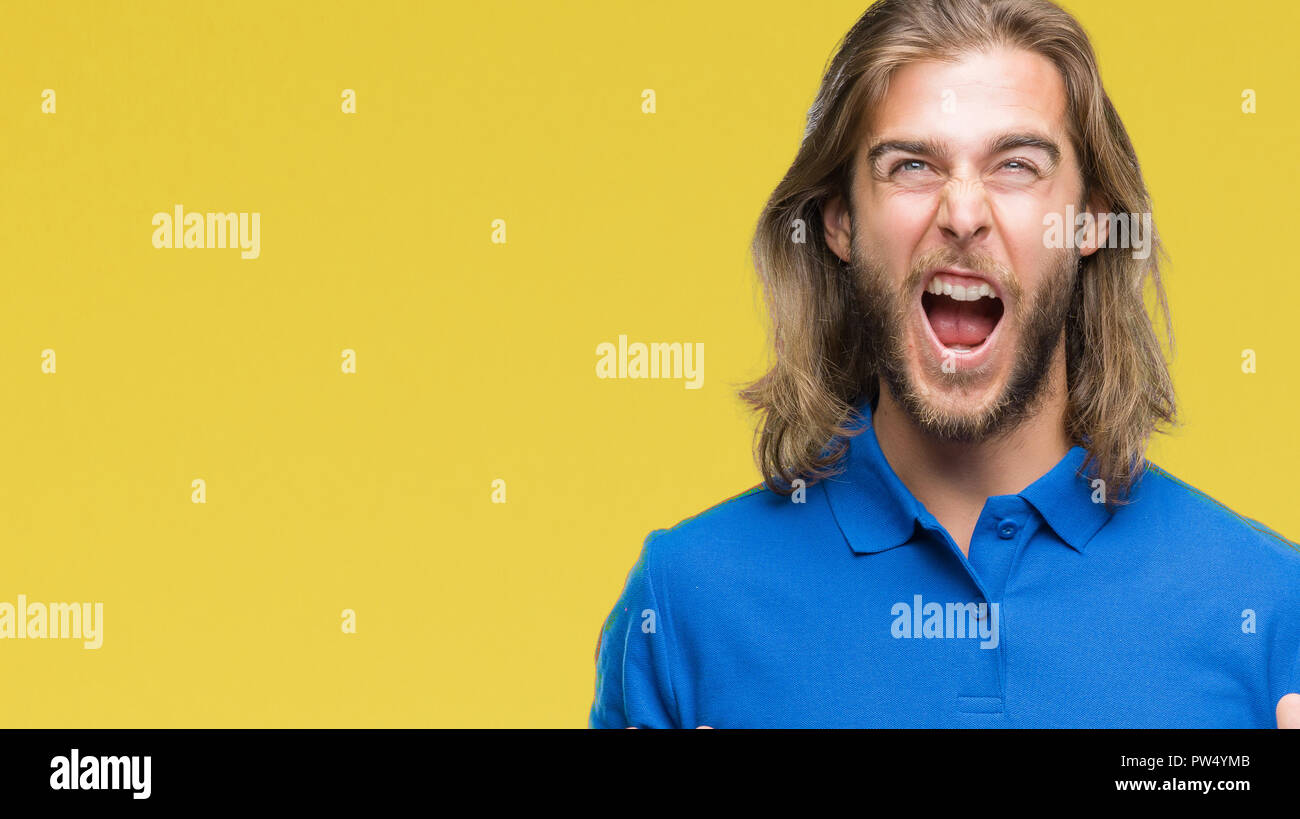 Young handsome man with long hair over isolated background crazy and ...