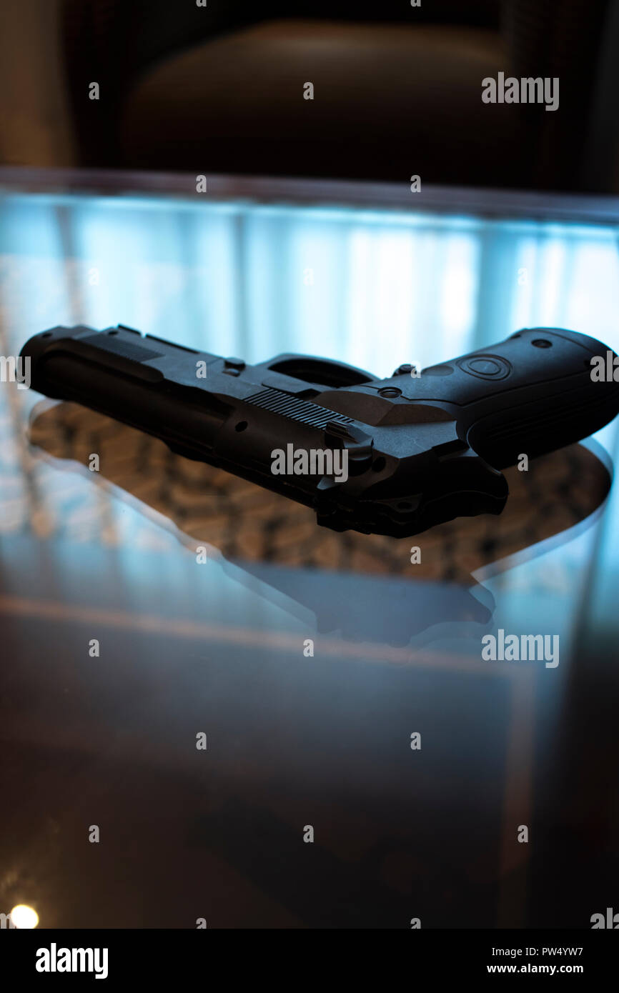 Automatic pistol gun on glass table in bedroom in luxury hotel in ...