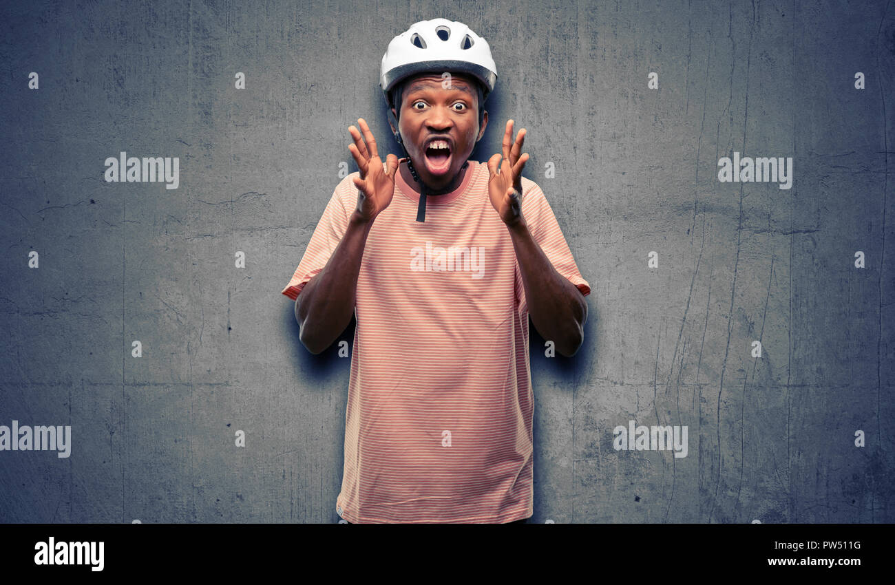 Black man wearing bike helmet stressful keeping hands on head ...