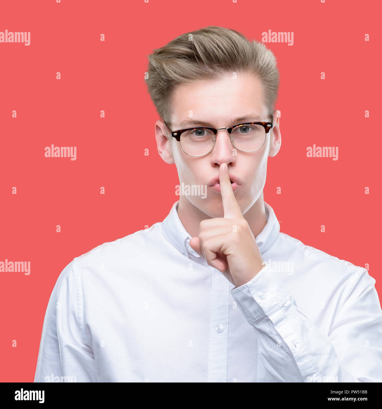 Young handsome blond man asking to be quiet with finger on lips ...