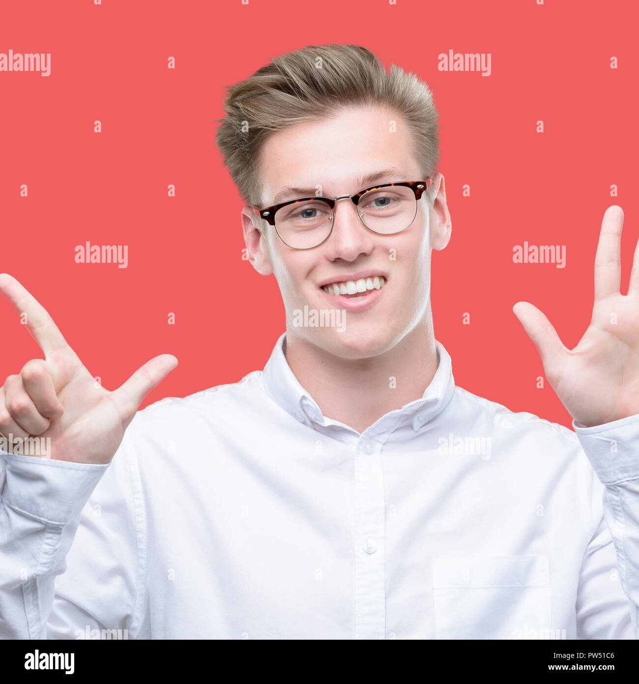 Young handsome blond man showing and pointing up with fingers number ...