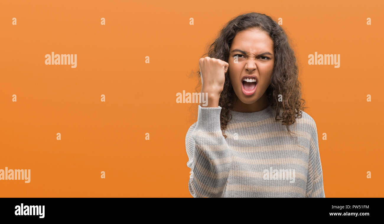 Beautiful young hispanic woman wearing stripes sweater angry and mad ...