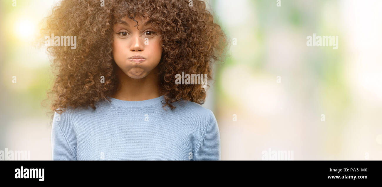 African american woman wearing a sweater puffing cheeks with funny face ...