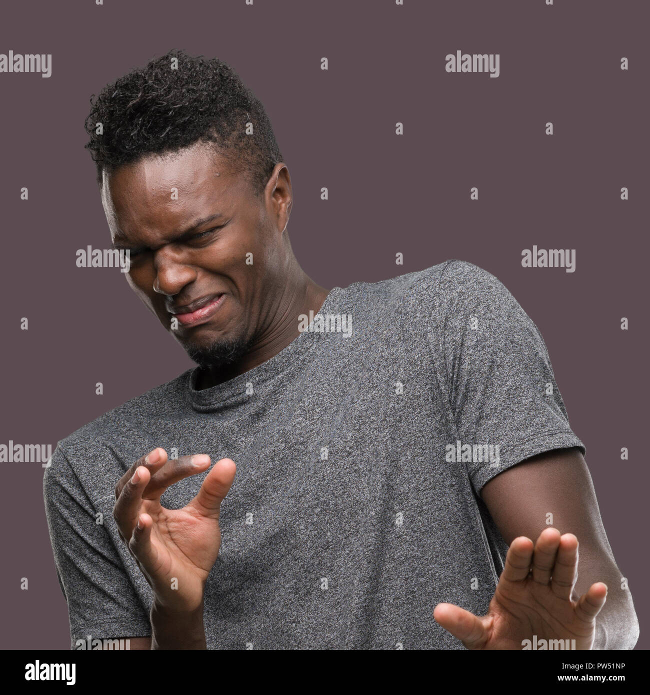 Young african american man wearing grey t-shirt disgusted expression ...