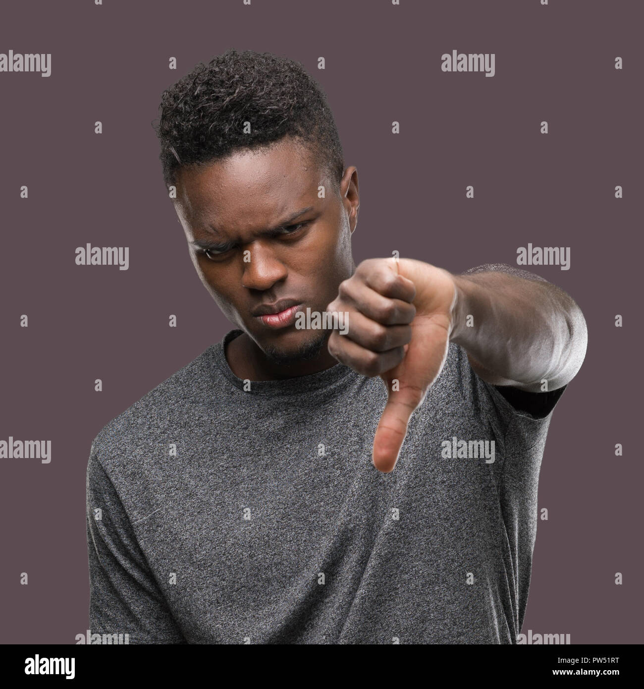 Young african american man wearing grey t-shirt looking unhappy and ...